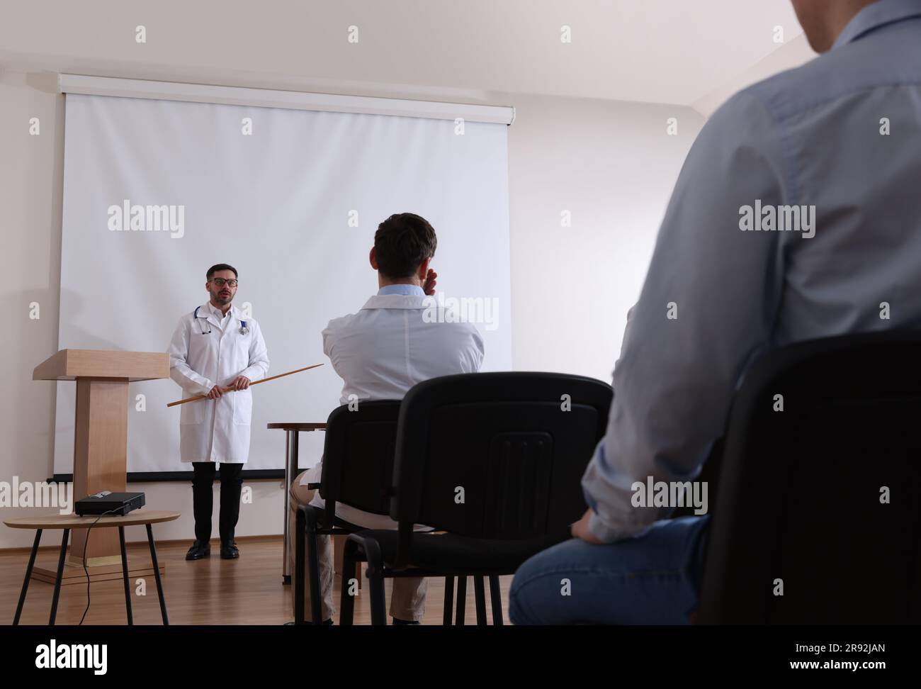 Doctor giving lecture in conference room with projection screen Stock ...