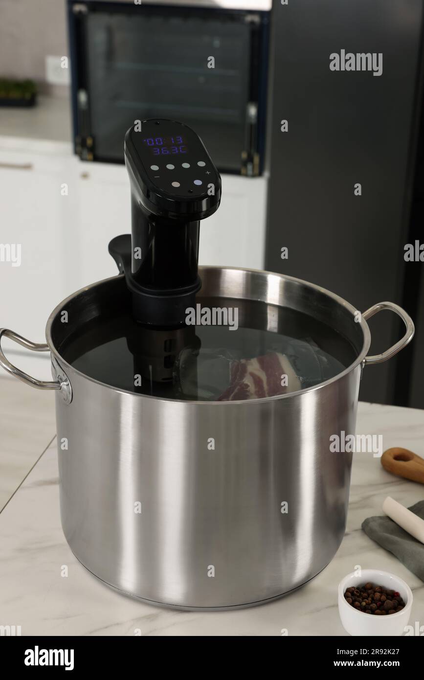 Pot with sous vide cooker on table indoors. Thermal immersion circulator Stock Photo - Alamy