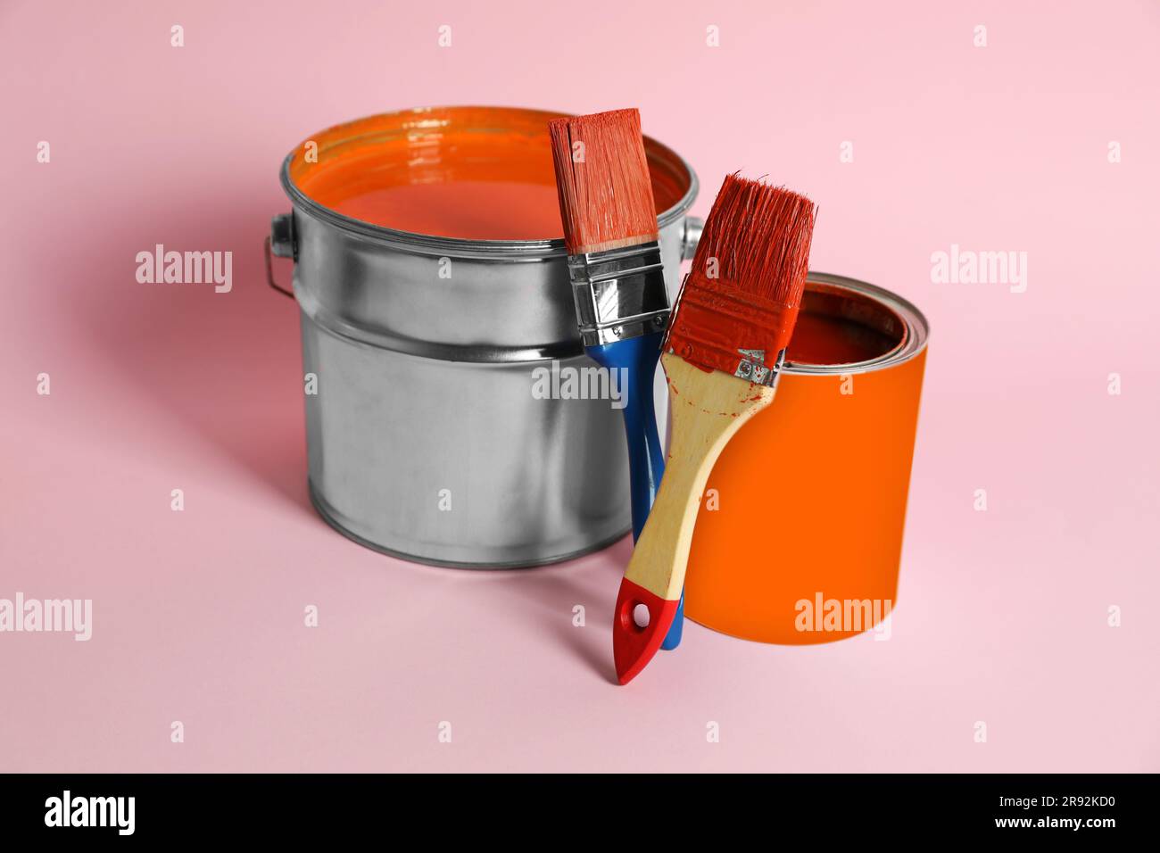 Bucket of orange paint, can and brushes on pink background Stock Photo ...