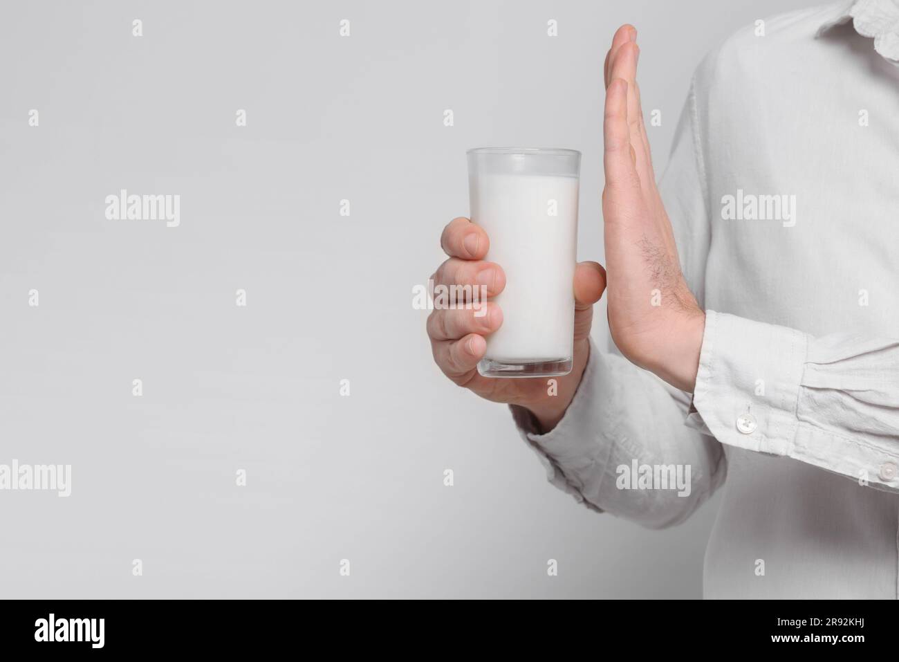 Man with glass of milk suffering from lactose intolerance on white ...