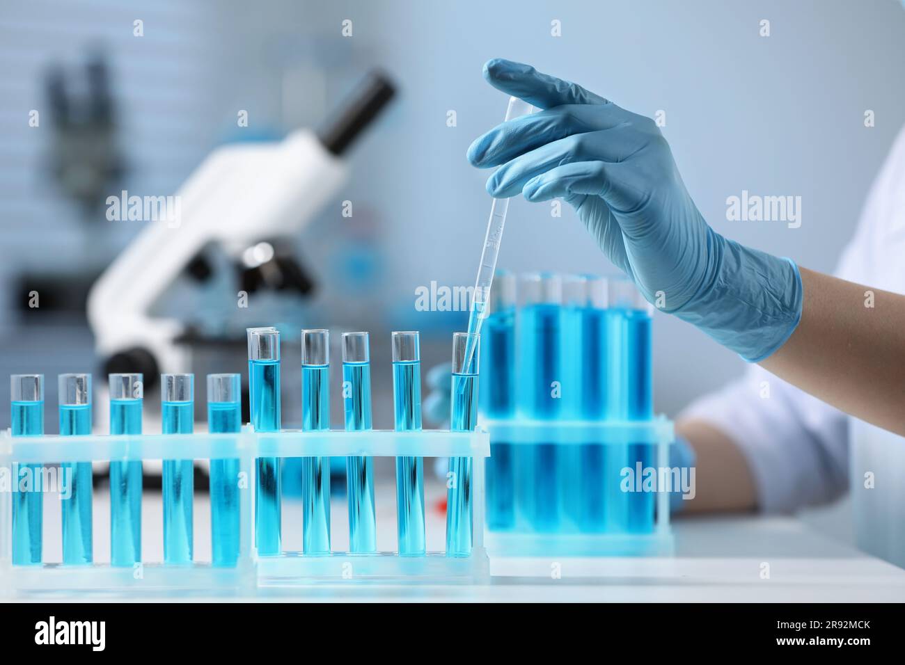 Scientist taking sample with dropper from test tube in laboratory ...