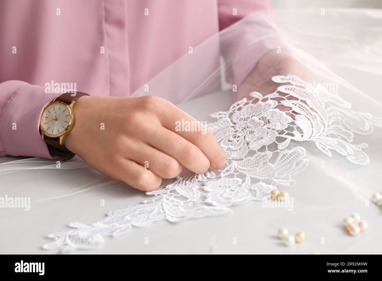 Dressmaker working with beautiful white lace at table in atelier ...