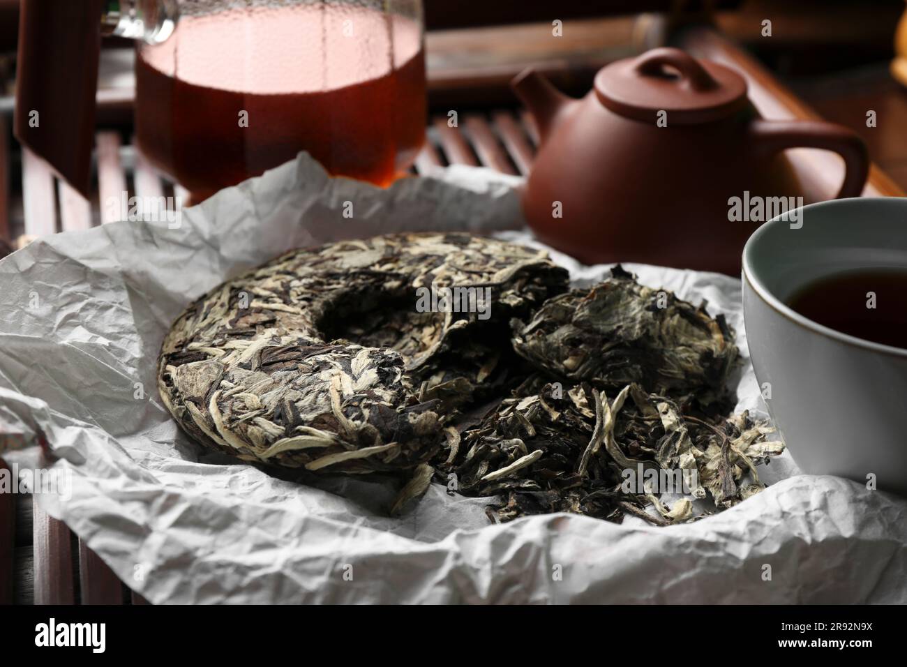 Broken disc shaped pu-erh tea on parchment paper, closeup. Traditional ...