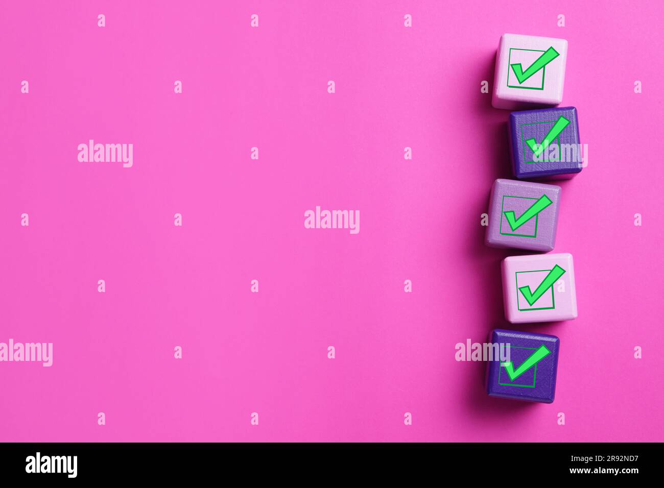 Cubes with check marks on pink background, flat lay. Space for text ...