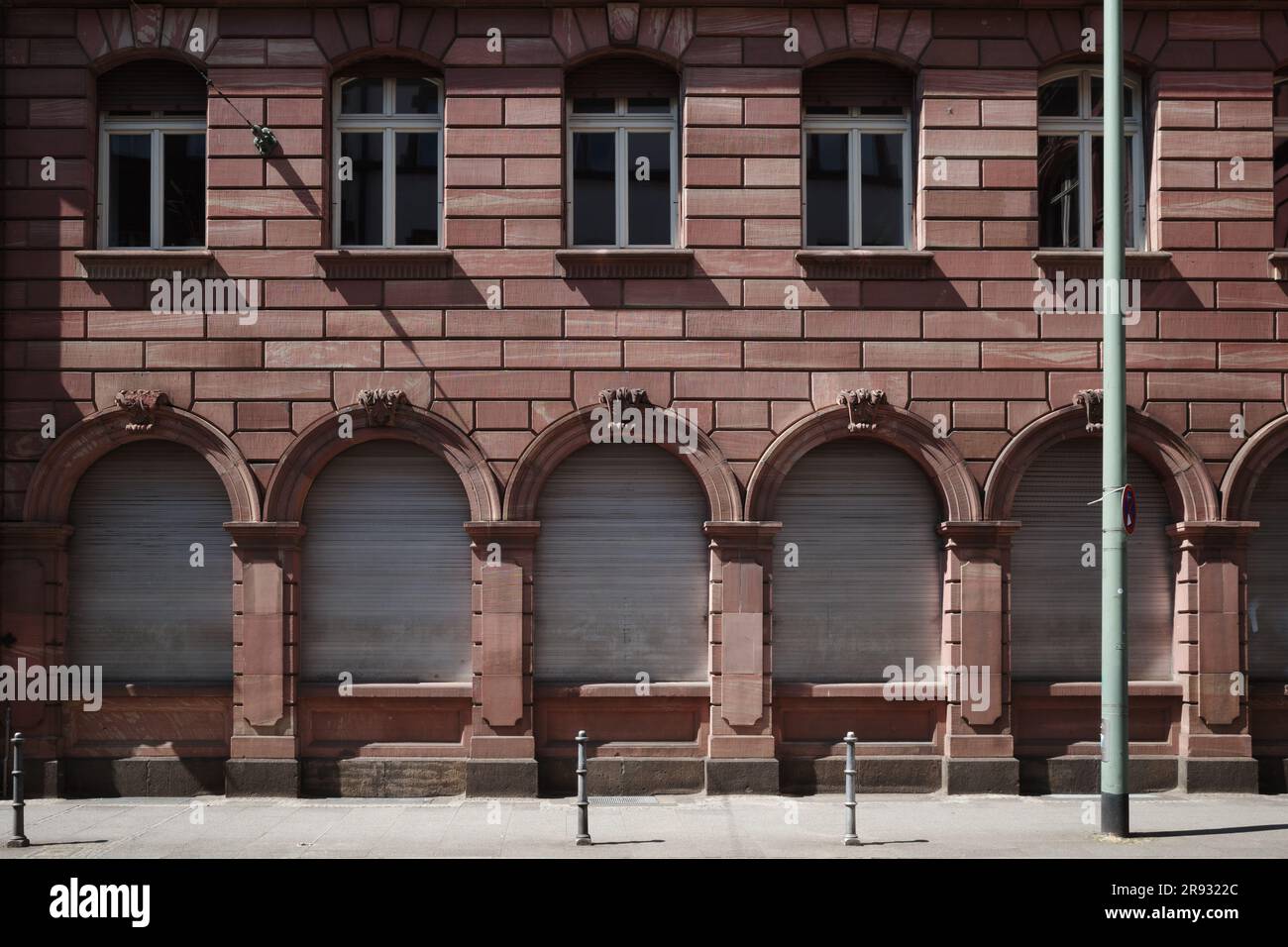 Outdoor sunny street view of sidewalk and stone red sandstone facade ...