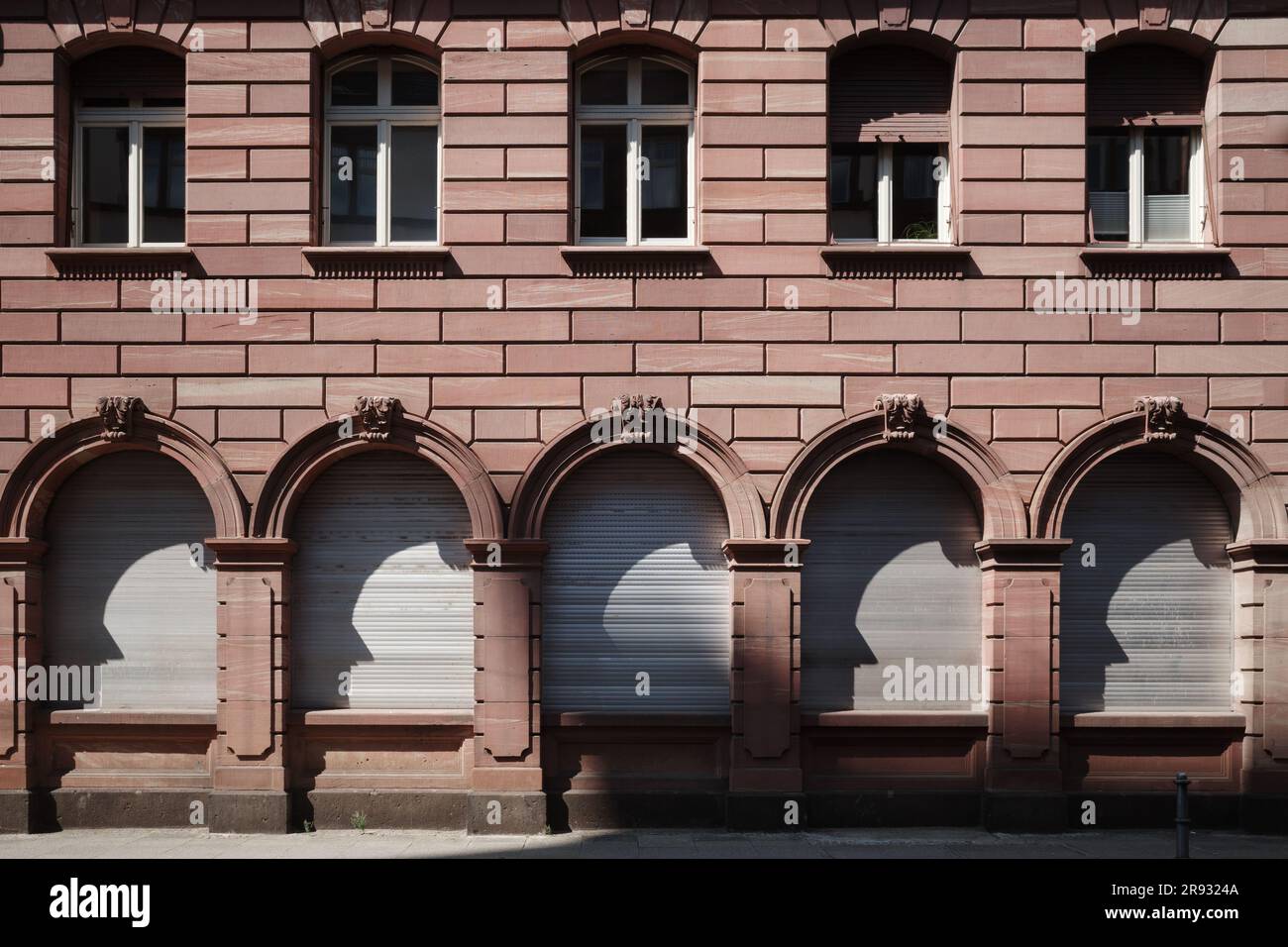 Outdoor sunny street view of sidewalk and stone red sandstone facade ...