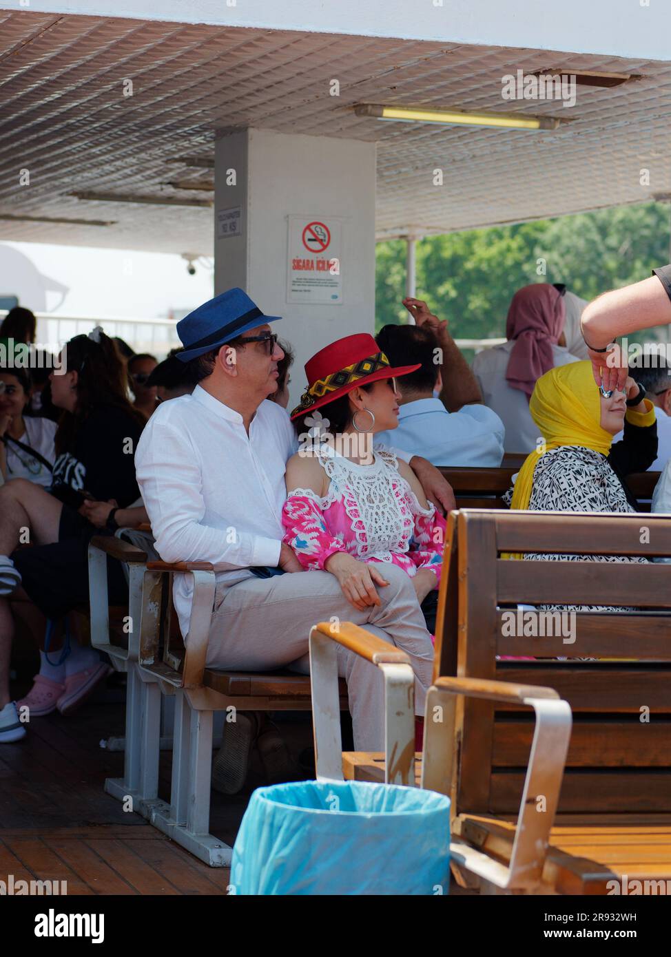 Couple in blue and red hats on a passenger ferry on the Sea of Marmara ...