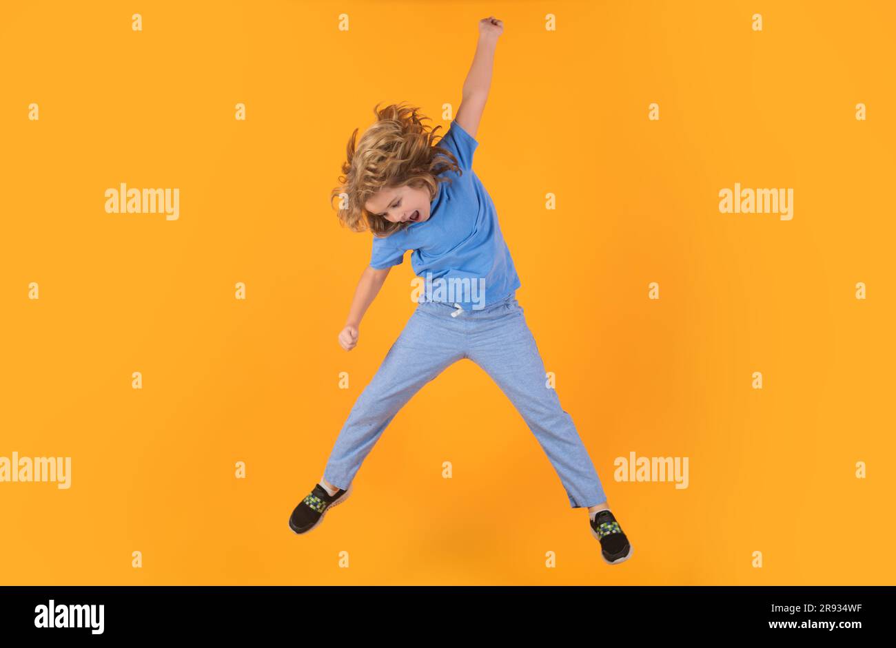 Funny boy jumping. Energetic kid boy jumping and raising hands up on ...