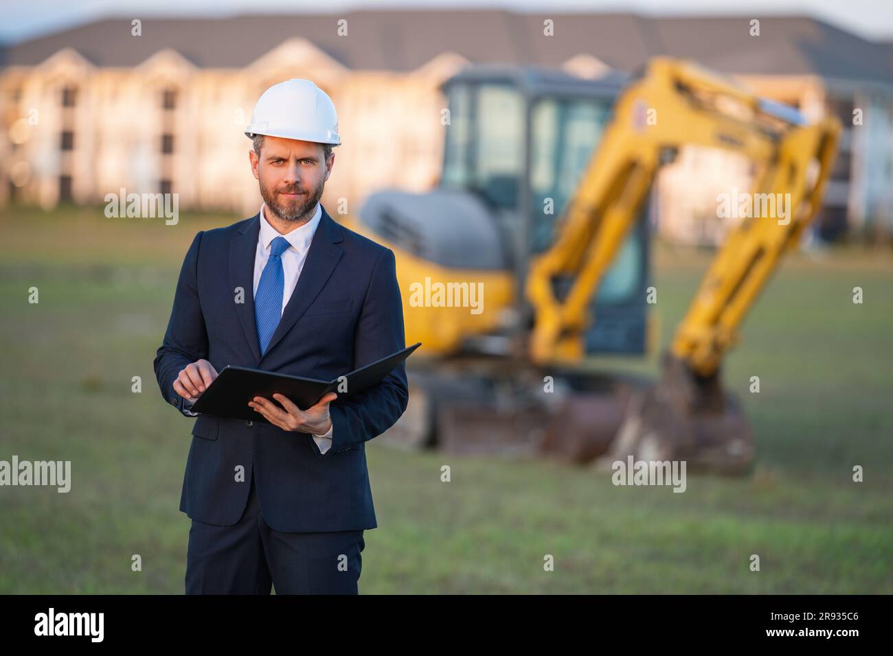 Architect at a construction site. Architect man in helmet and suit at ...