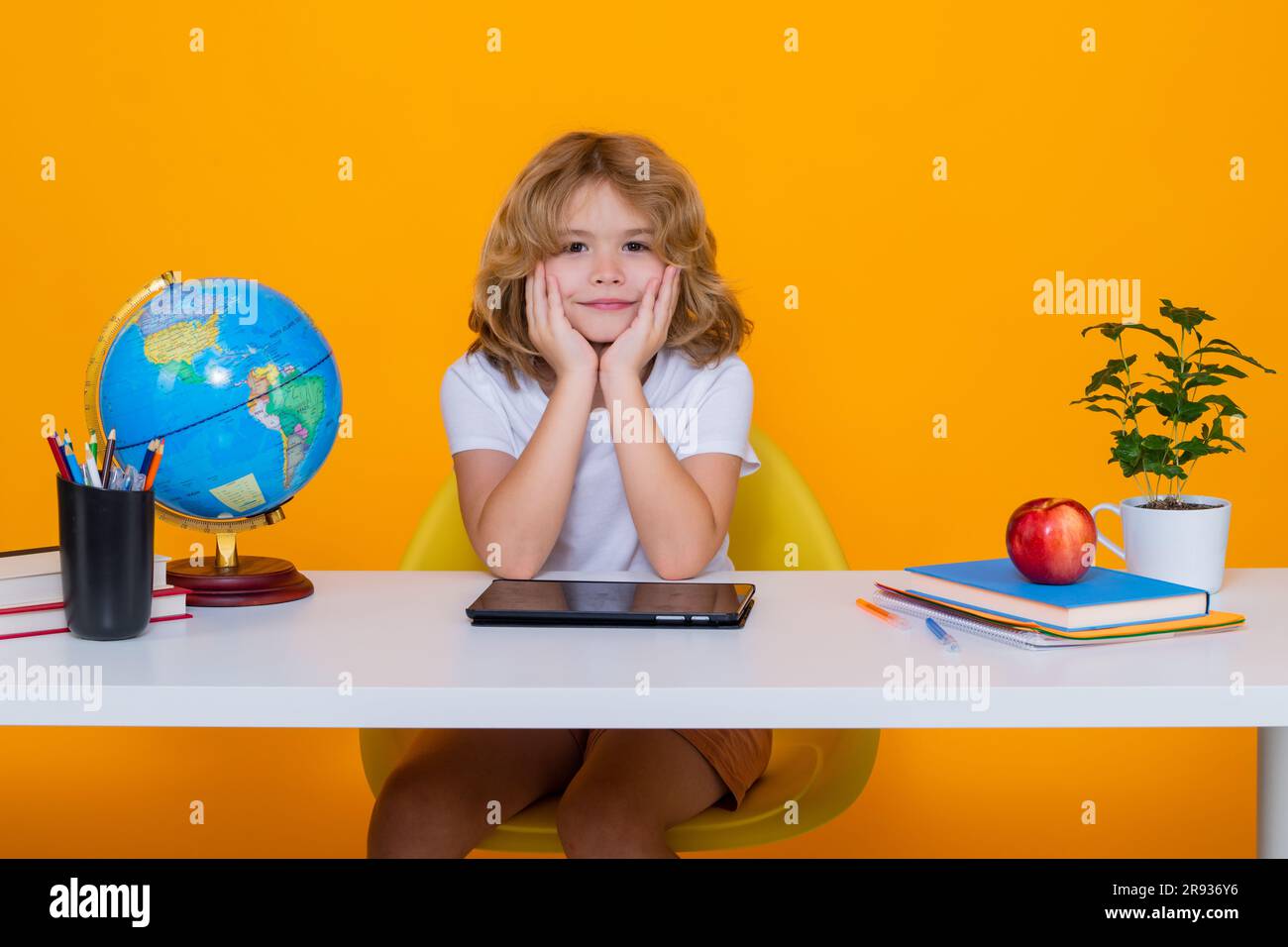 School child portrait isolated on yellow studio background. Kid boy ...