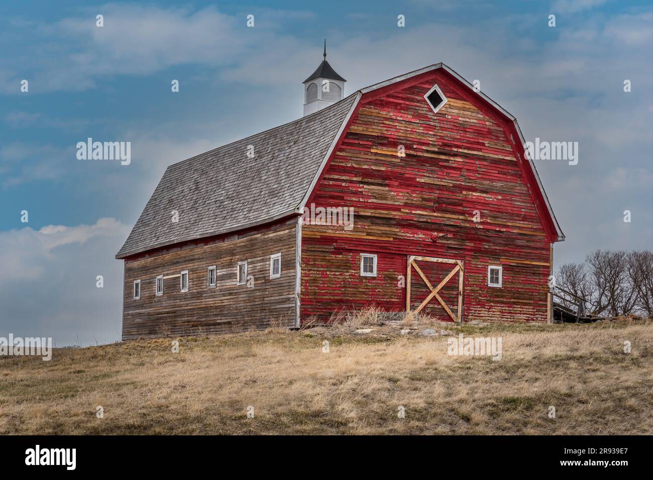 An abandoned red barn with a wagon ramp on the prairies in Saskatchewan ...