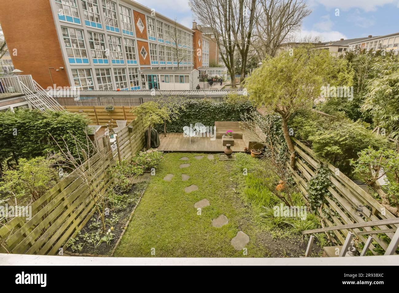 an urban garden with wooden fences and green grass in the area is ...