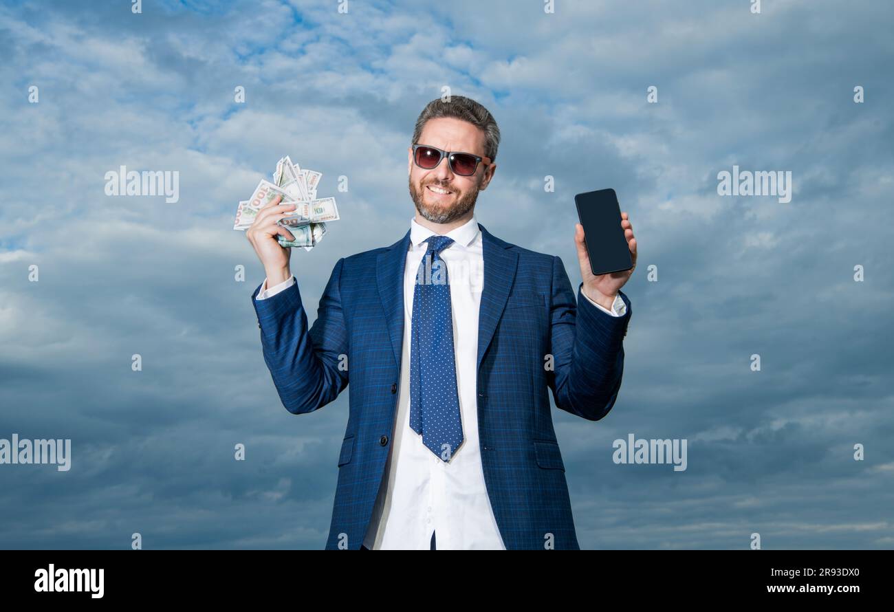 Happy rich man businessman holding cash money and smartphone. Money ...