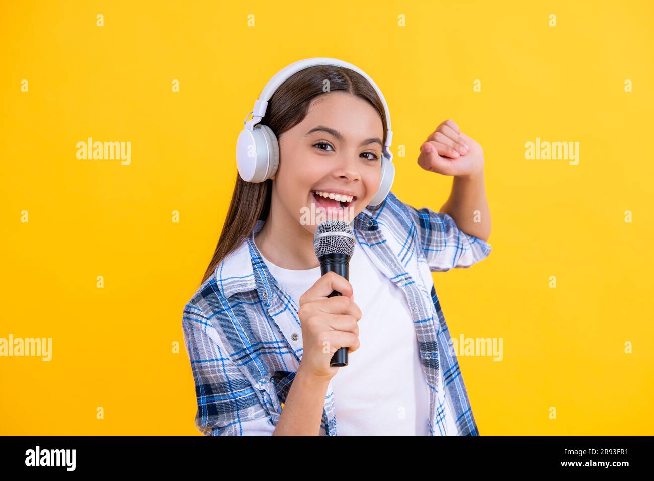 smiling music singer girl in headphones. young girl singing into music ...