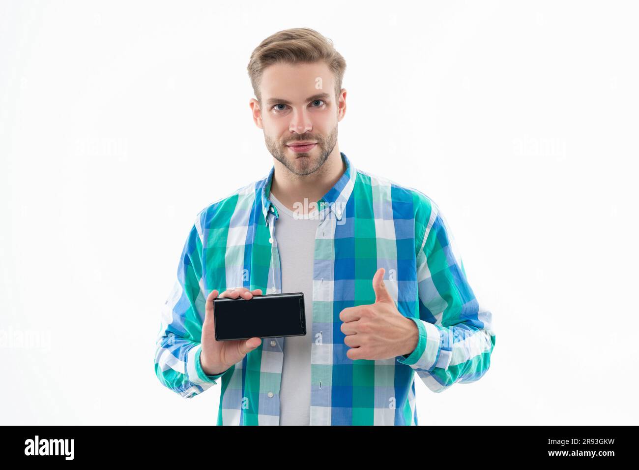 man shows phone screen in studio, thumb up. man showing phone screen on ...