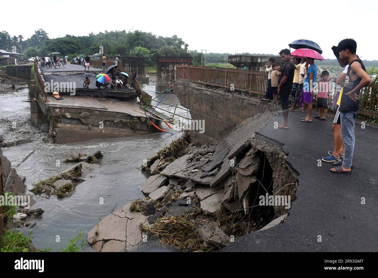 Baksa. 23rd June, 2023. People look over a section of a bridge washed away during a flash flood ...