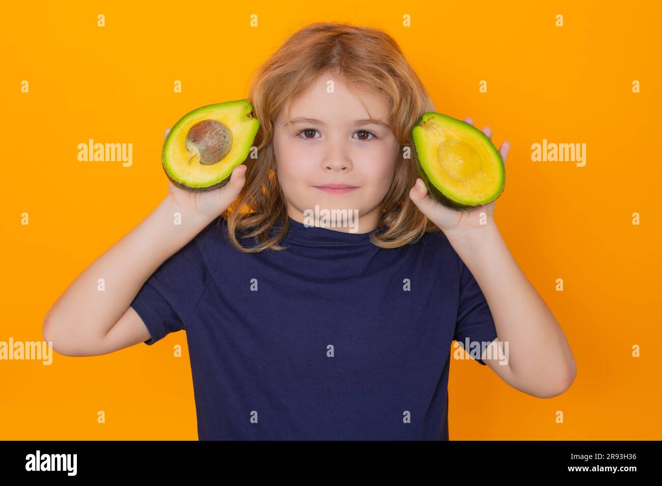 Vitamin and healthy fruits for kids. Kid hold red avocado in studio ...