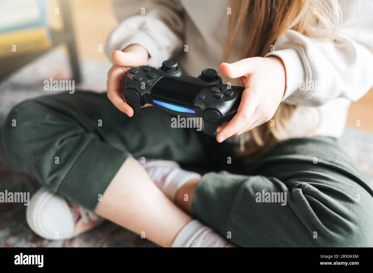 A little girl holding game controller playing video games Stock Photo ...