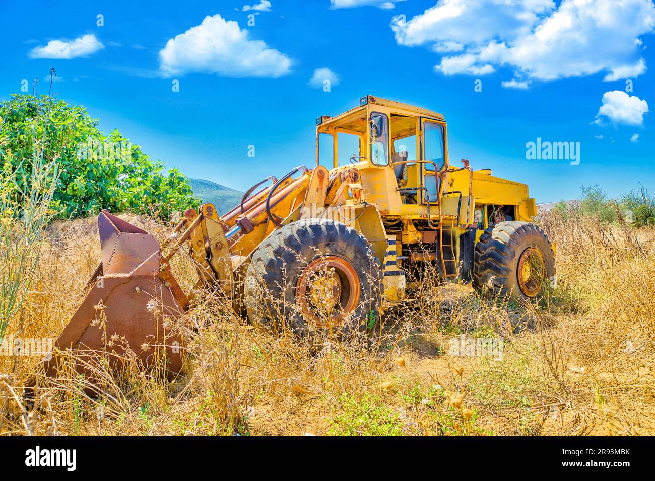 Side view of a yellow bulldozer on wheels for agriculture in a high ...