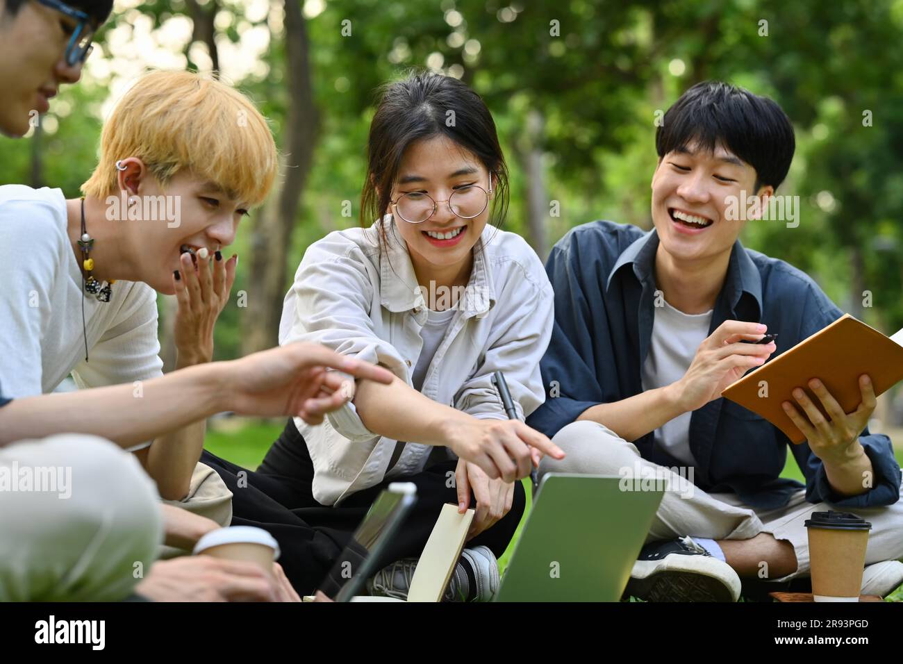 Happy university students doing group project together in university ...