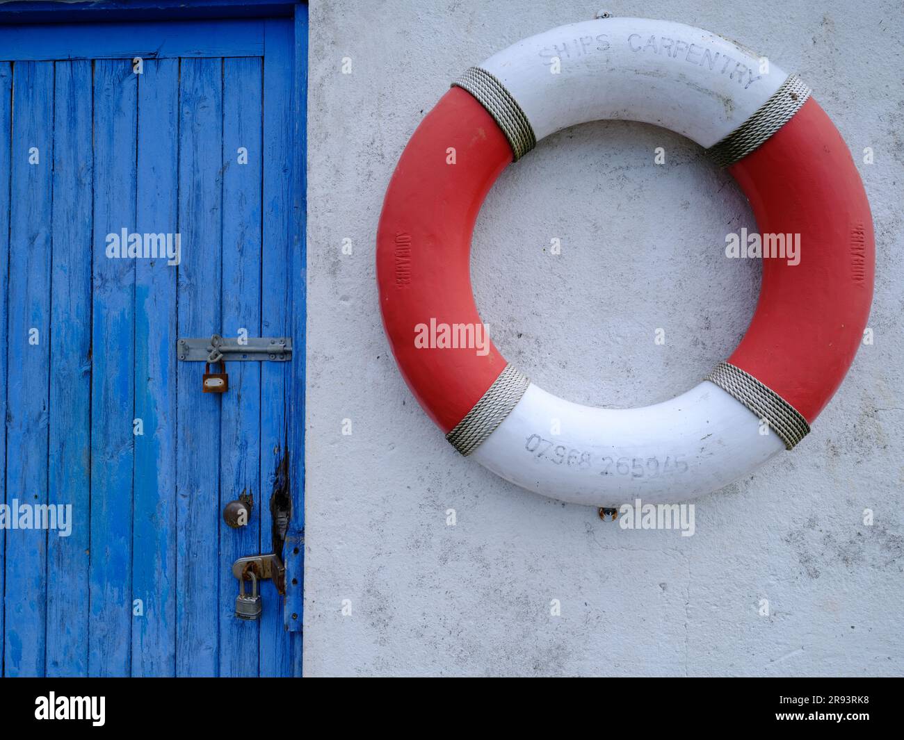 LIFEBUOY AND WEATHERED DISTRESSED BLUE DOOR NEWLYN HARBOUR Stock Photo ...