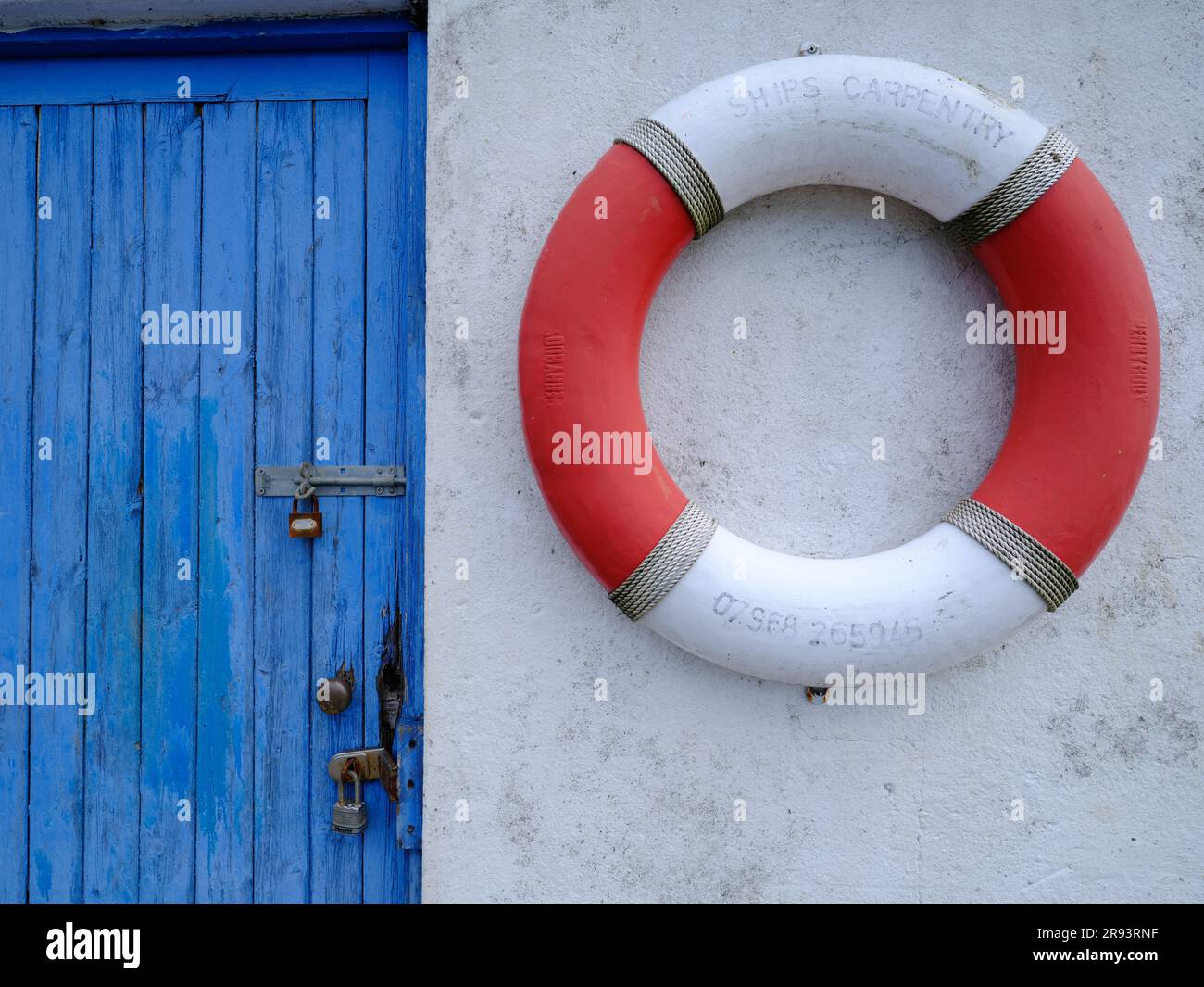LIFEBUOY AND WEATHERED DISTRESSED BLUE DOOR NEWLYN HARBOUR Stock Photo ...