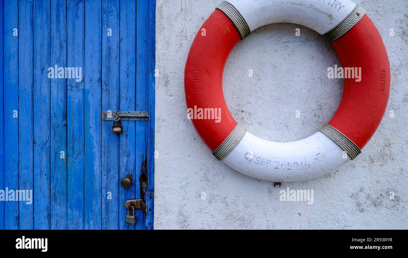 LIFEBUOY AND WEATHERED DISTRESSED BLUE DOOR NEWLYN HARBOUR Stock Photo ...
