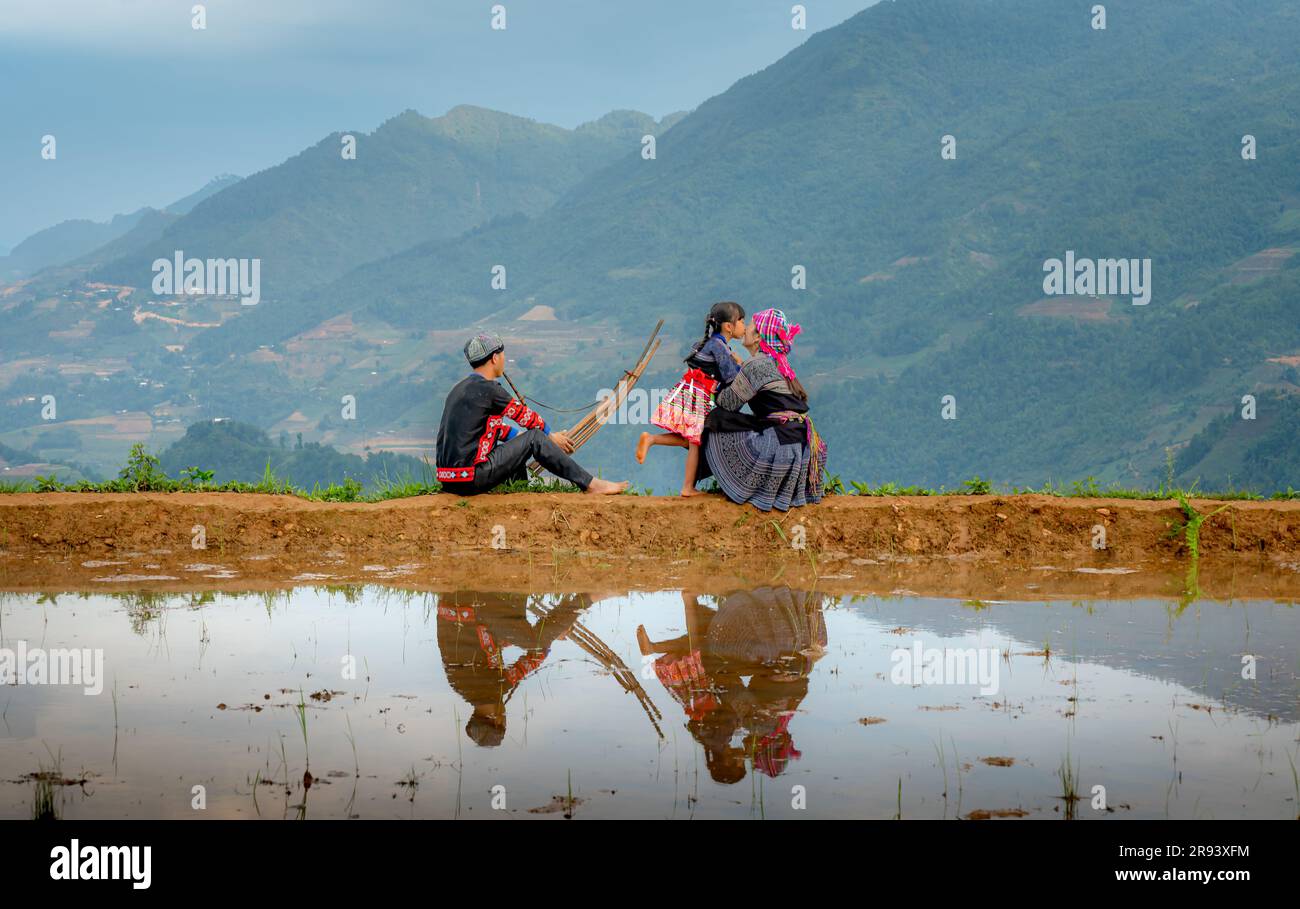A young H'mong family relaxes by a terraced field in Mu Cang Chai, Yen ...