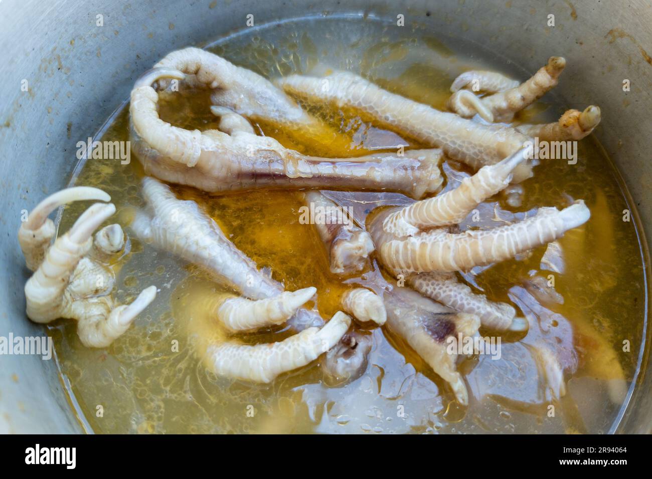 boiled chicken paws with broth in aluminium casserole for natural dog ...