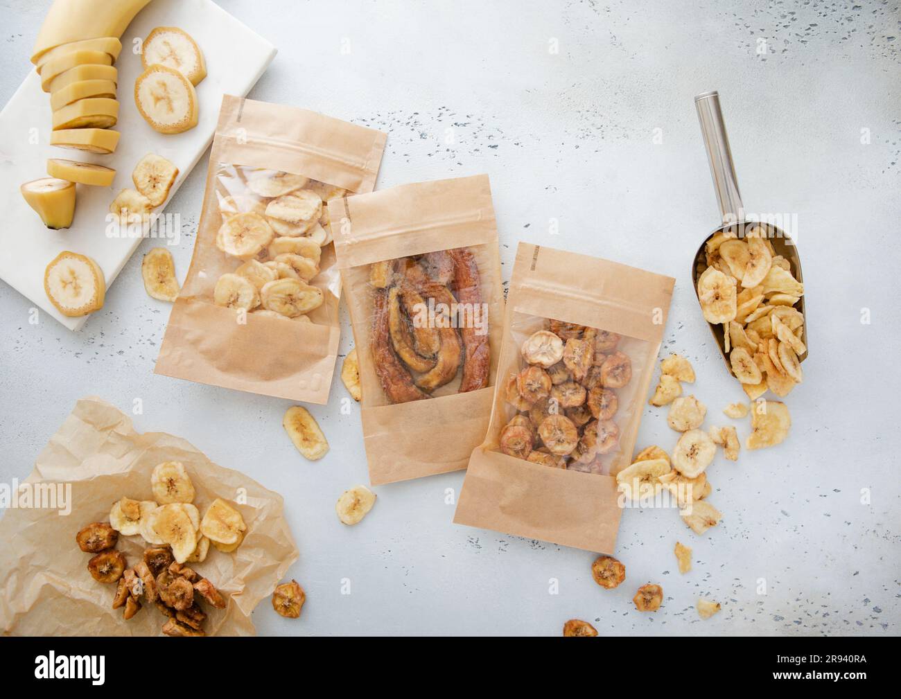 Packages of various crunchy and chewy banana slices with scoop on light ...