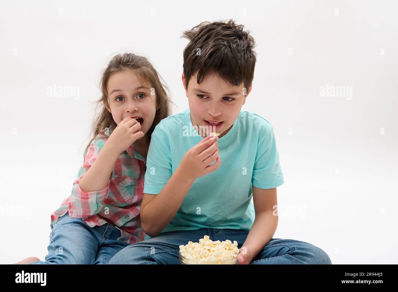Happy kids, boy and girl eating popcorn, watching movie, smiling ...