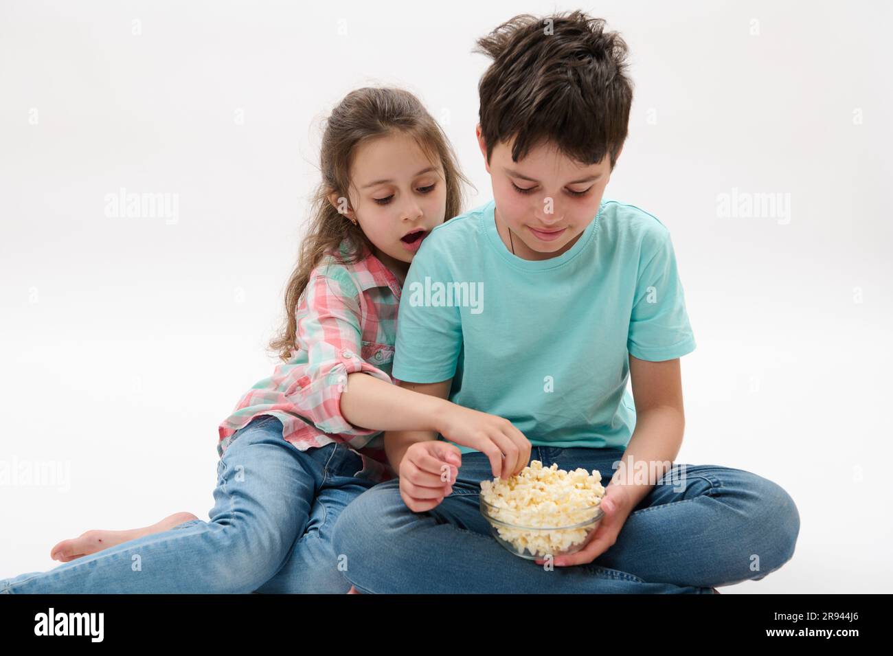 Beautiful kids - teenage boy and preschooler girl eating tasty salted ...