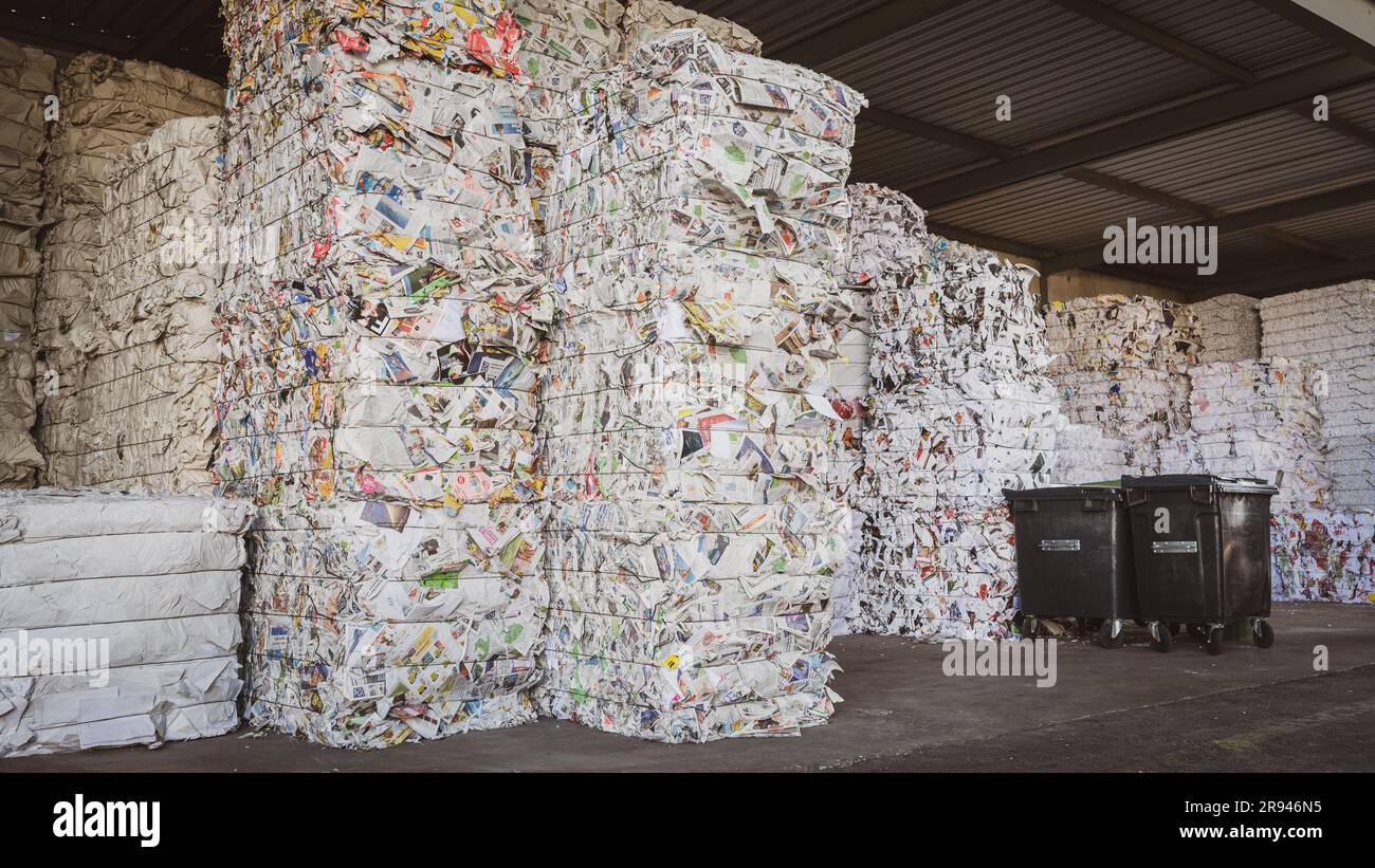 Stacked packages of shredded waste paper for recycling and garbage bin ...