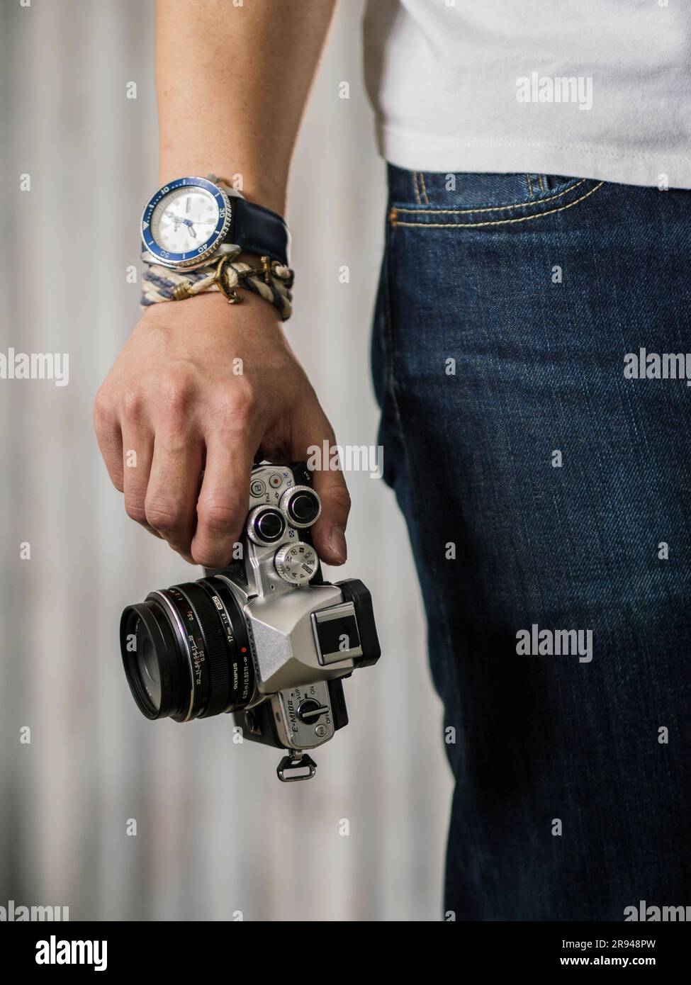 Man in white shirt and blue jeans with Right hand holding camera ...