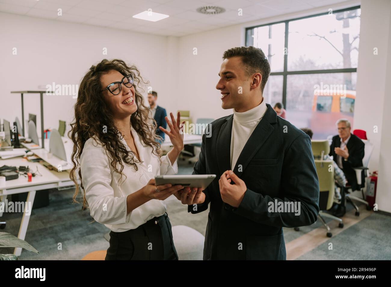 Two partners pointing a on the tablet and talking about something a the ...