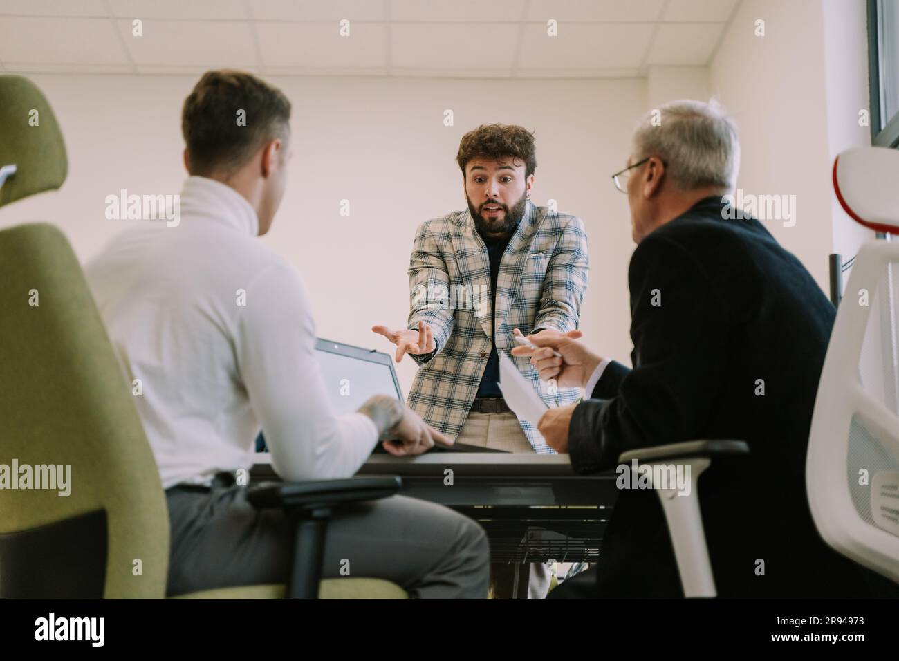Disappointed and angry boss overlooking and warning his employees at ...