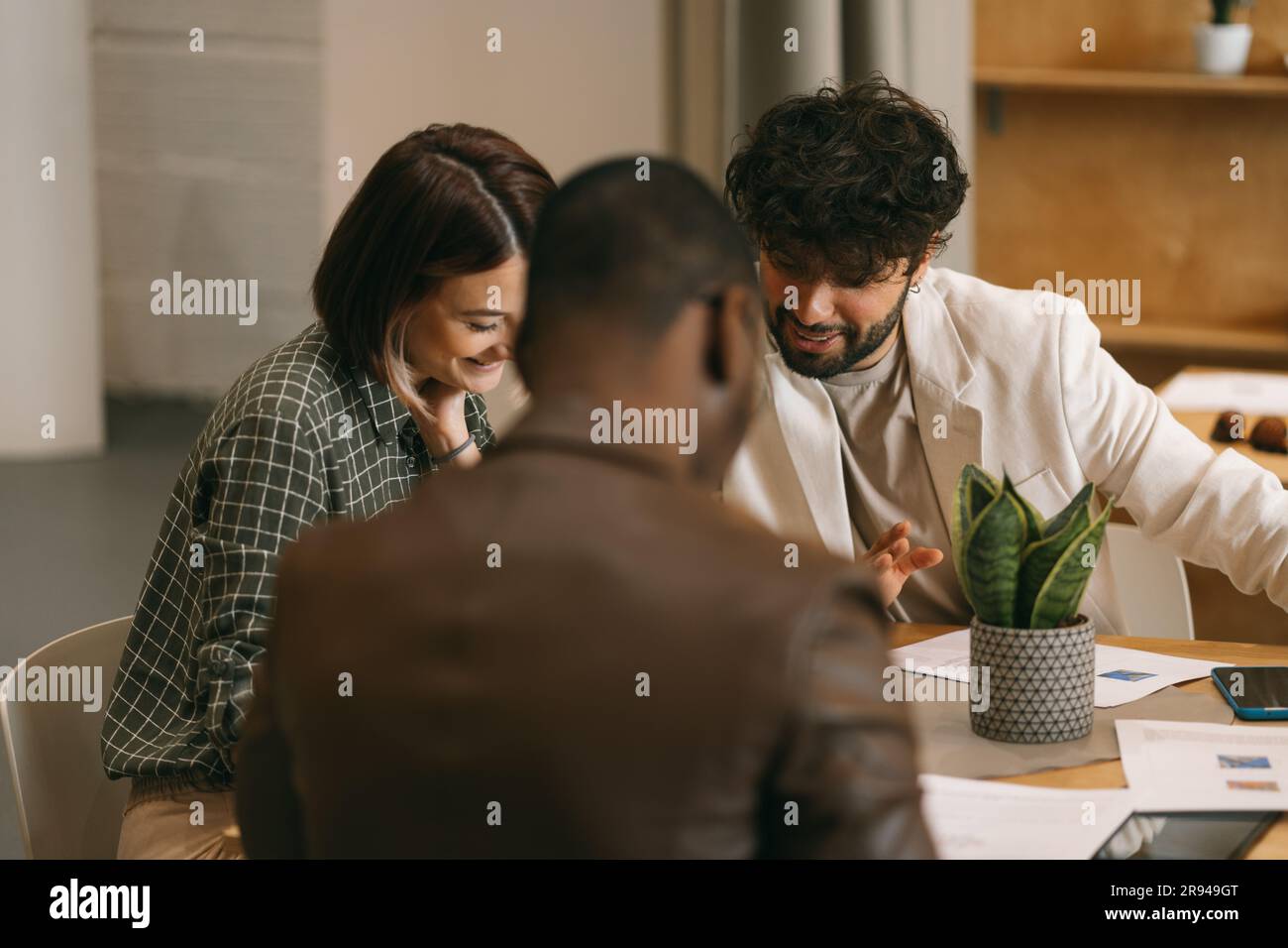 Beautiful, young, multiracial colleagues having fun conversation and ...