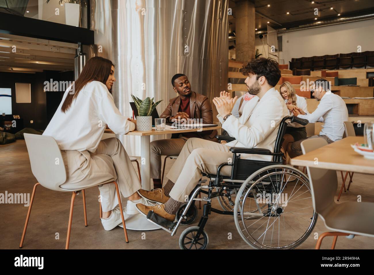 Good looking handicapped male person in wheelchair working together ...