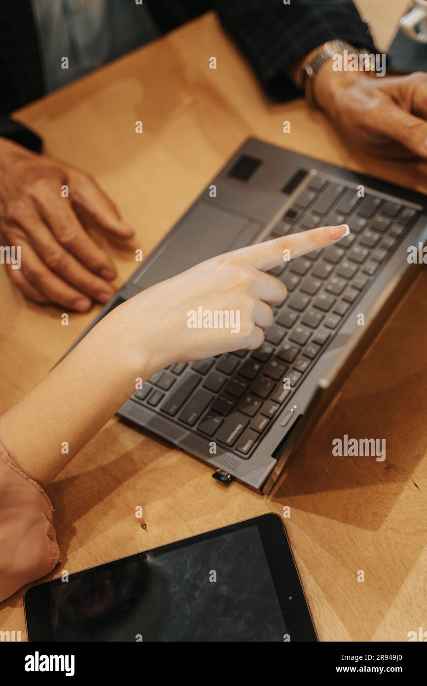 Female employee pointing at the lap top Stock Photo - Alamy