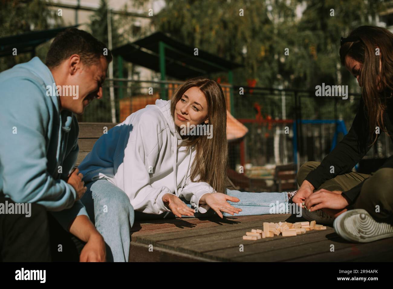Close up of blonde girl showing the scattered jenga to her friends ...