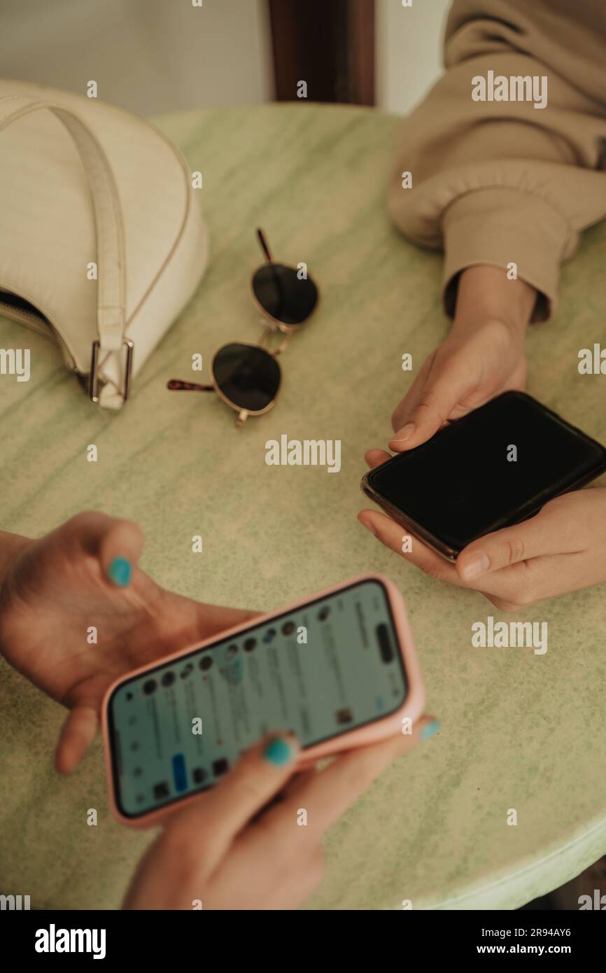 Close up shot of three girls checking their phones Stock Photo - Alamy