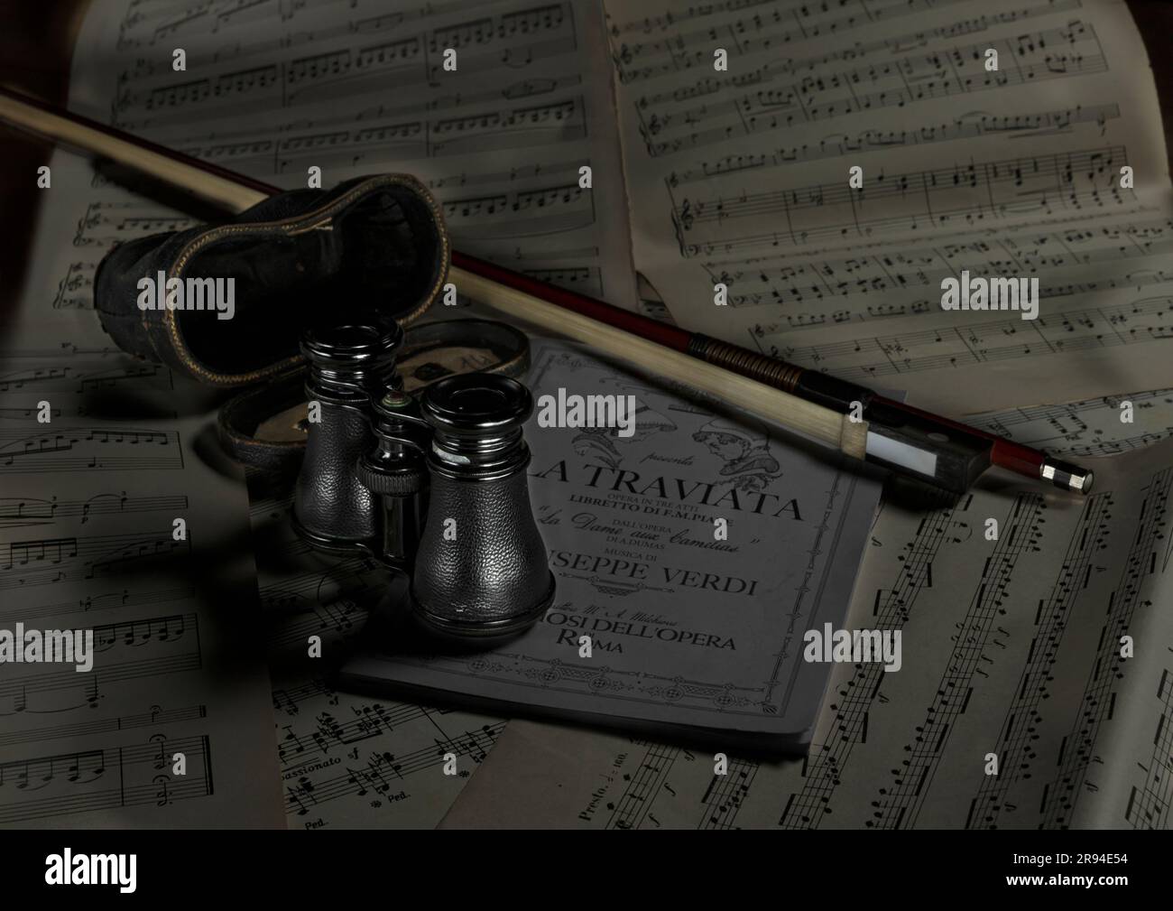 Opera glasses sitting on sheet music with opera programme and violin ...