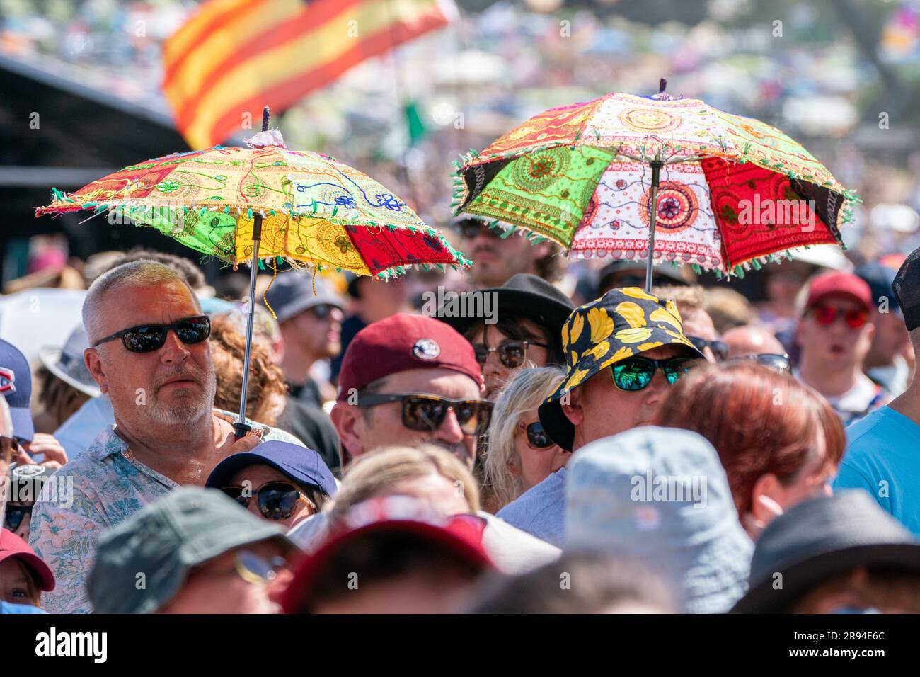 People shade from the sun using colourful parasols in the crowds at the ...