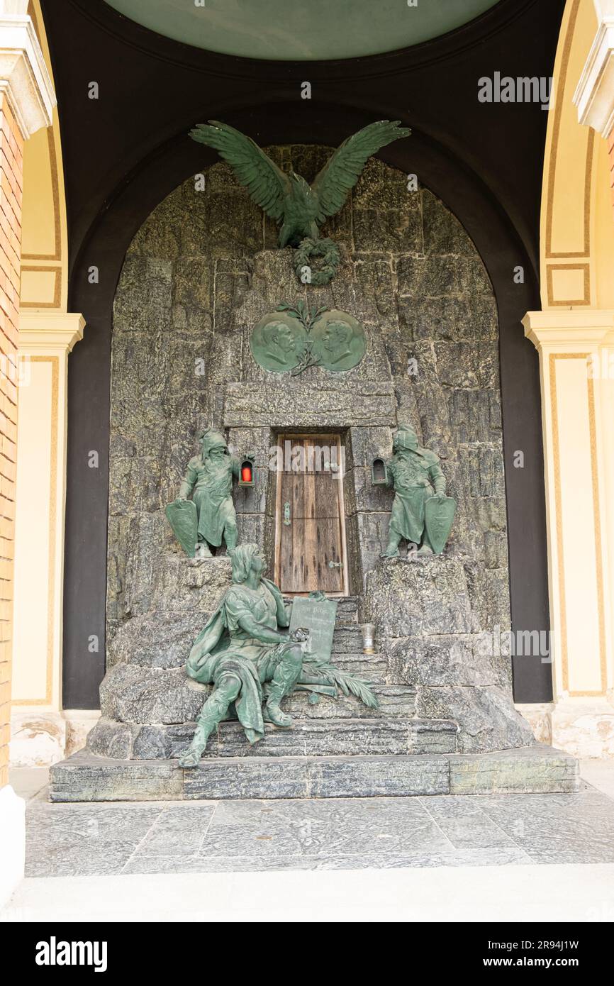 Dwarf statues and an old door on the wall of the crypt in the central ...