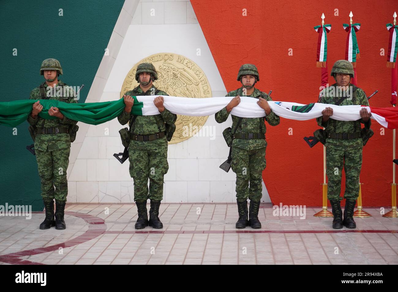 A group of military soldiers are standing in formation, each holding a ...