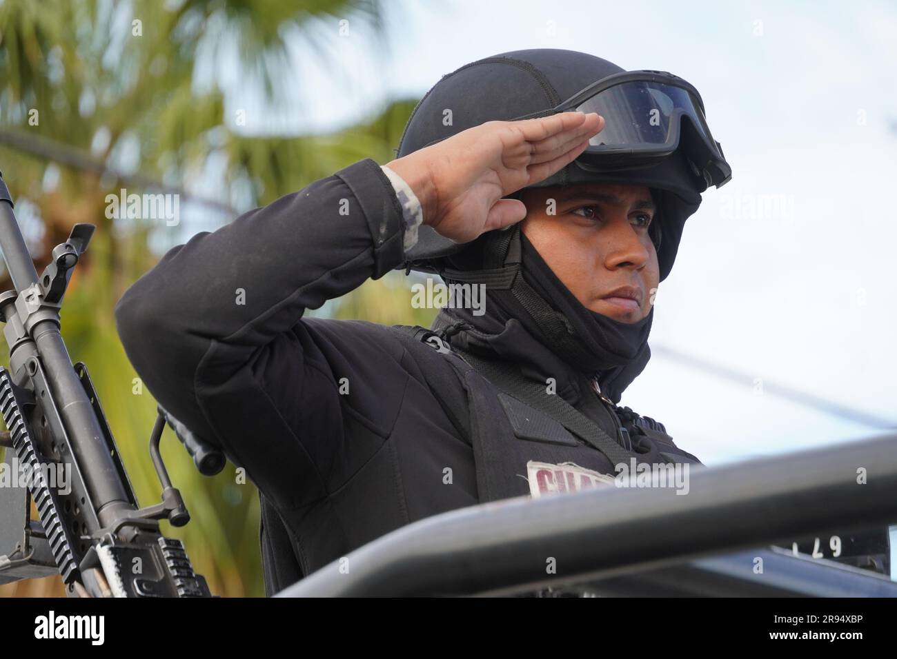 A police officer poses in full uniform, wearing a black helmet and ...