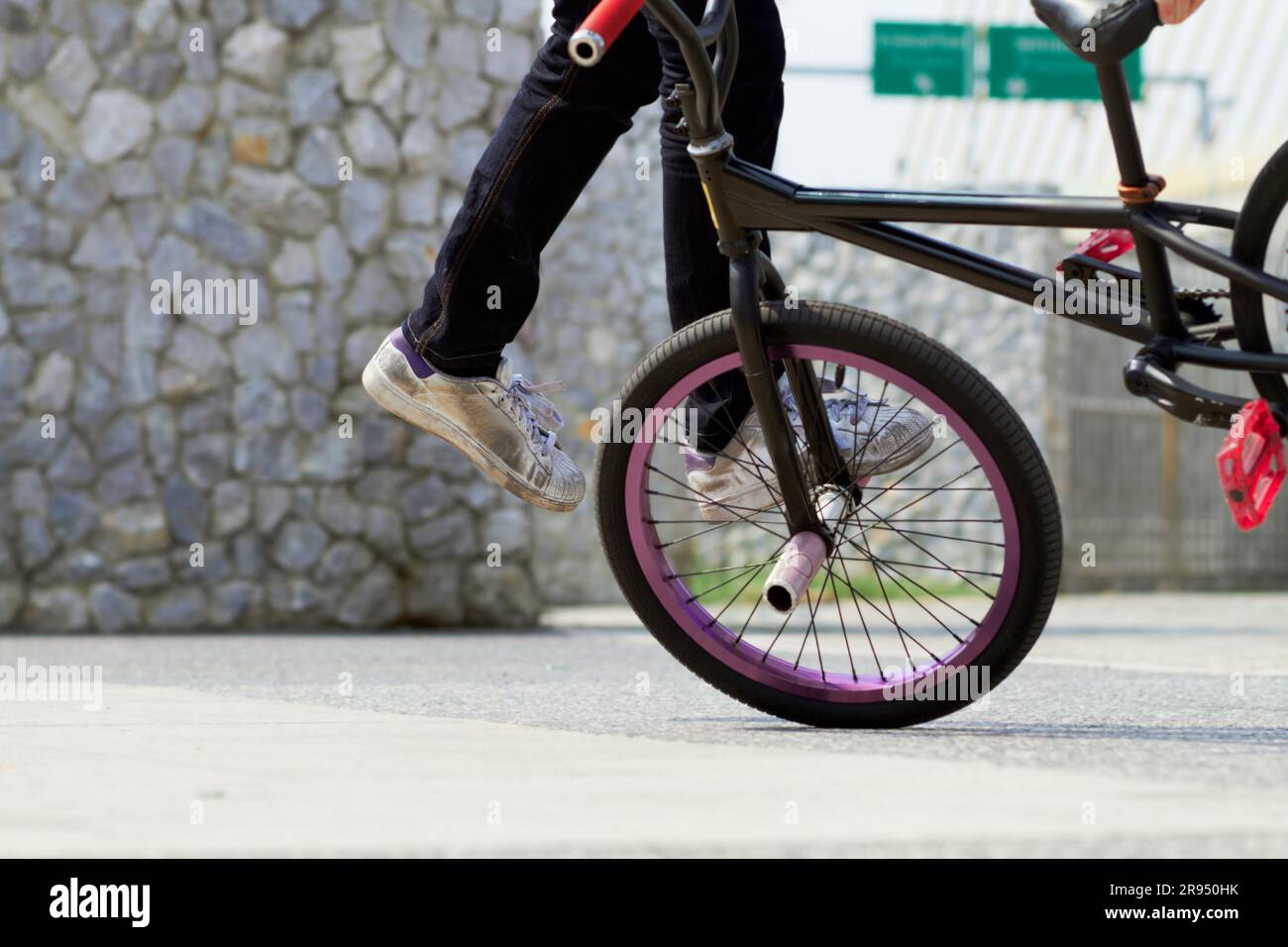 Legs, wheel and person on bicycle for trick, challenge and action at ...