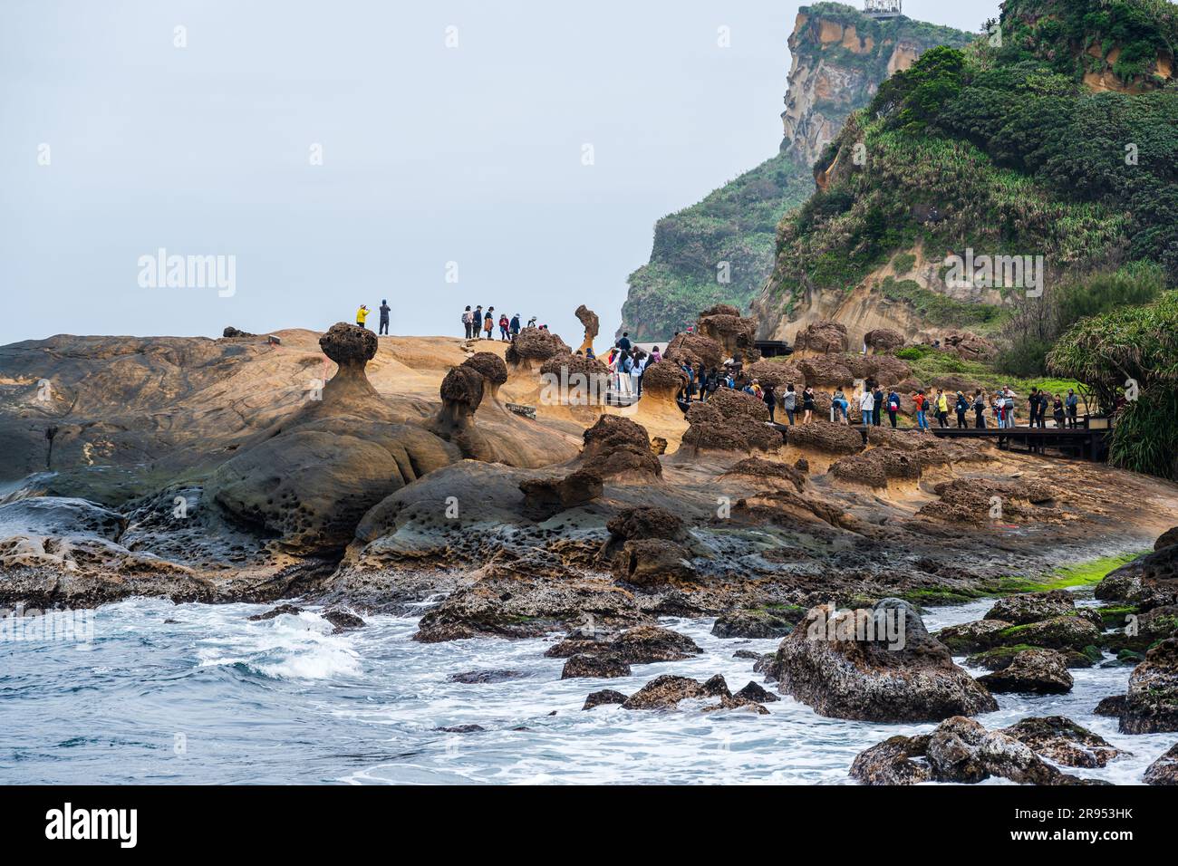 Yehliu Geopark, Taiwan -- March 14, 2023. Tourists clamber over rock ...