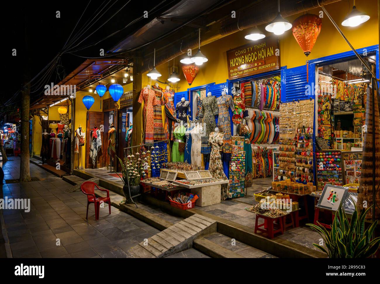 Clothes and souvenir shops with their goods on display along a street ...