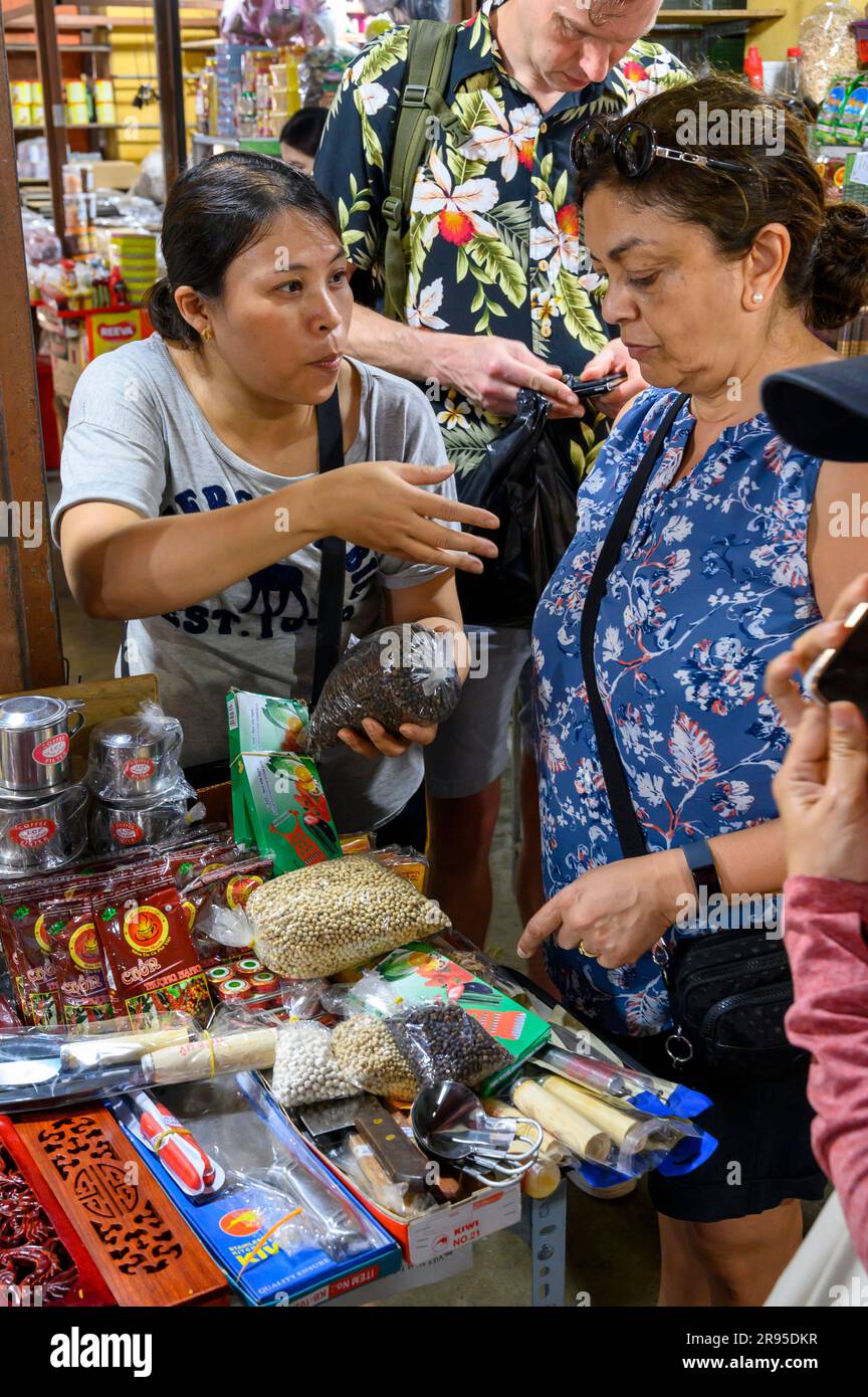 A spice vendor explains different types of peppercorns to a tourist in ... A spice vendor explains different types of peppercorns to a tourist in ...